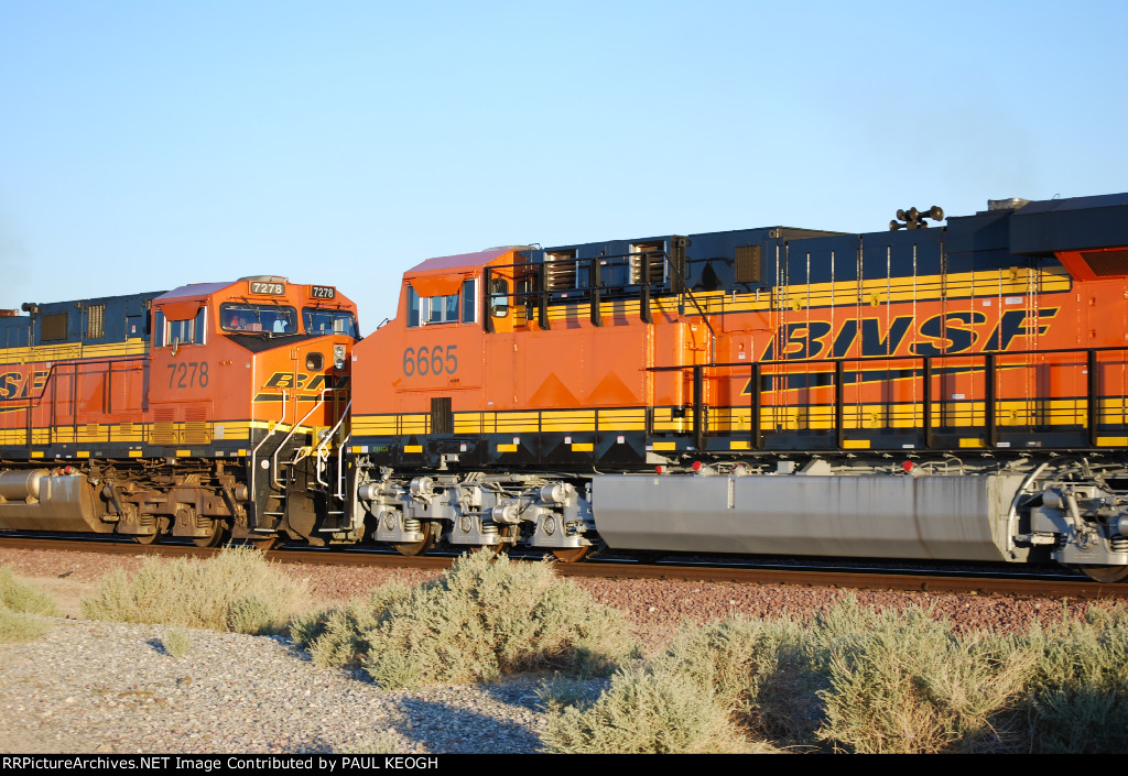 BNSF 6665 Gleems in the rising sun's rays at 06:56 am just west of BNSF Barstow yard as she ...